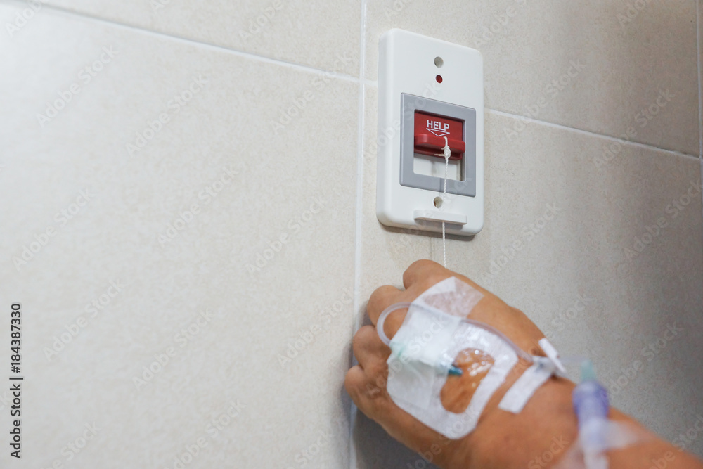 Old patient pulling a red switch calling for emergency help in the ...