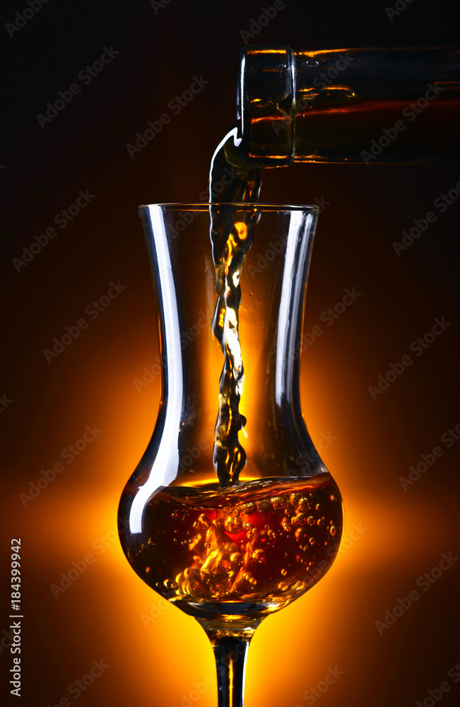 Pouring alcohol drink into a wineglass . Stock Photo | Adobe Stock