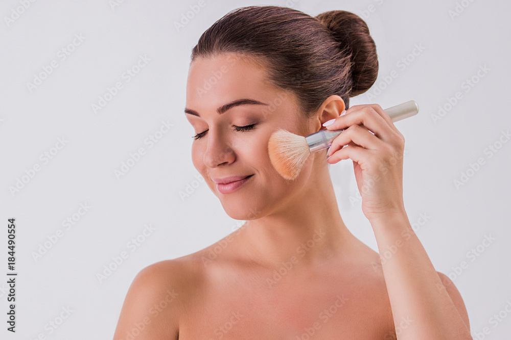 Make up for natural look. Portrait of beautiful shirtless girl applying ...