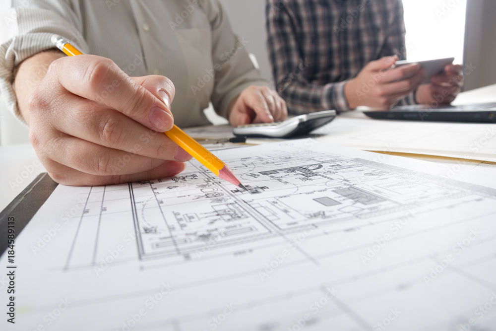 Architects working on blueprint, real estate project. Architect ...