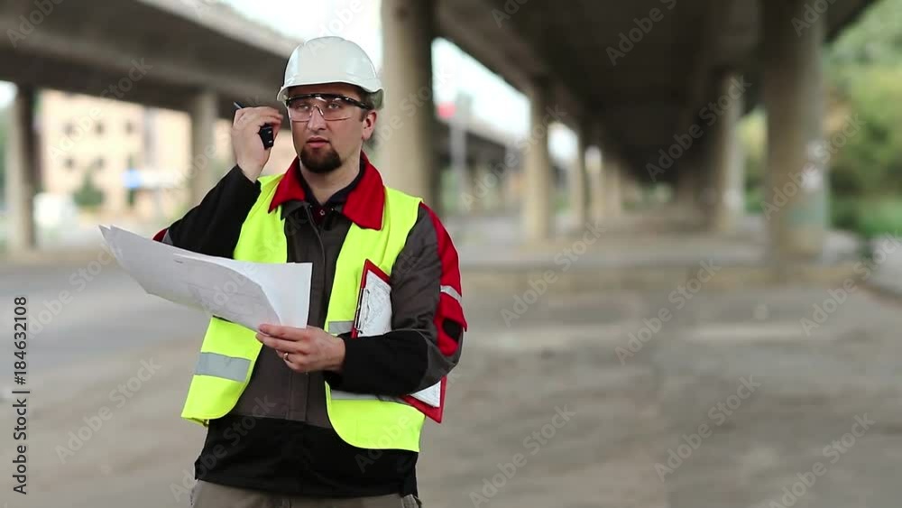 Road fettler with design drawings under overpass. Repairman with ...