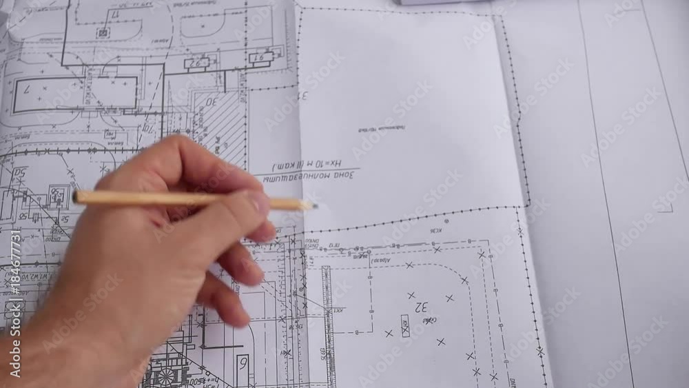 Macro close up of quantity surveyors hand reviewing technical drawing ...