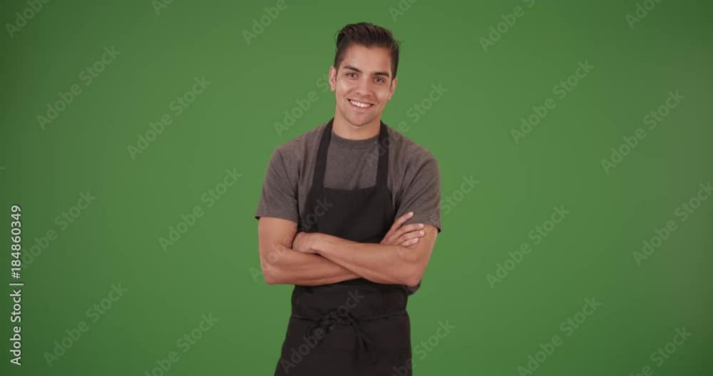 Happy handsome young Latino waiter on green screen. On green screen to ...