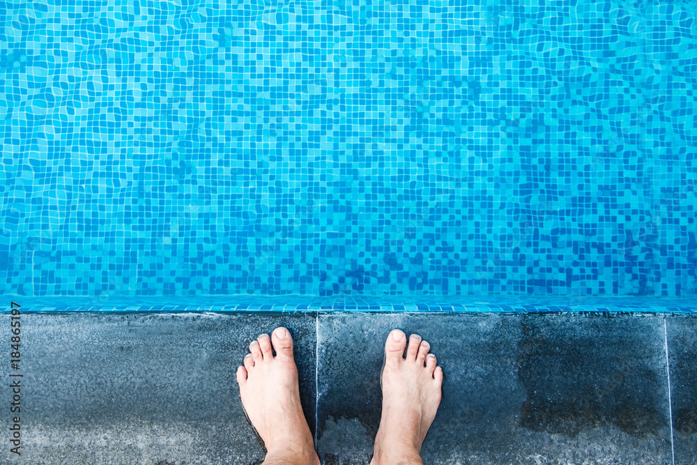 Selfie the feet at the pool side or edge with blue mosaic tiles at the ...