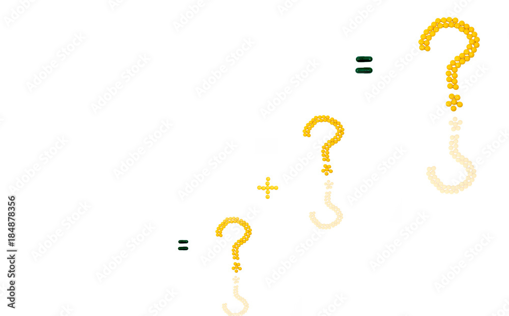 Three question mark and plus sign made of yellow sugar coated tablet ...