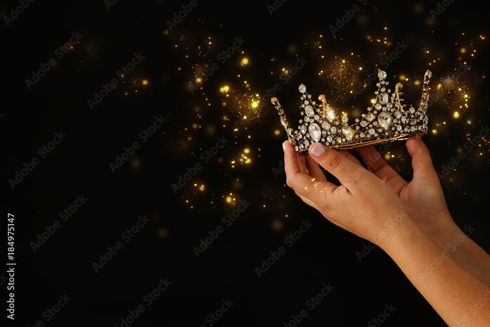 Woman's hand holding a crown for show victory or winning first place ...