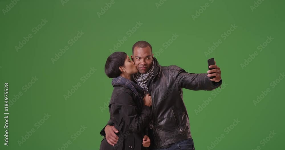 A black couple poses for a picture on green screen. On green screen to ...