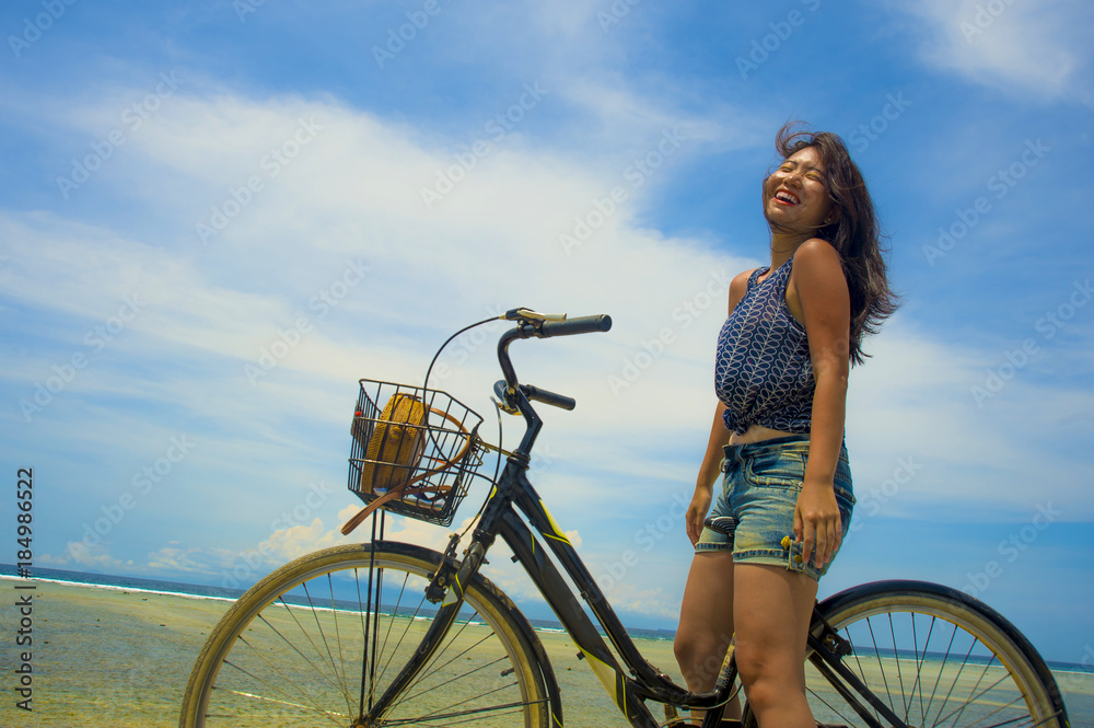 young pretty and happy Asian Chinese girl riding vintage bicycle on the ...