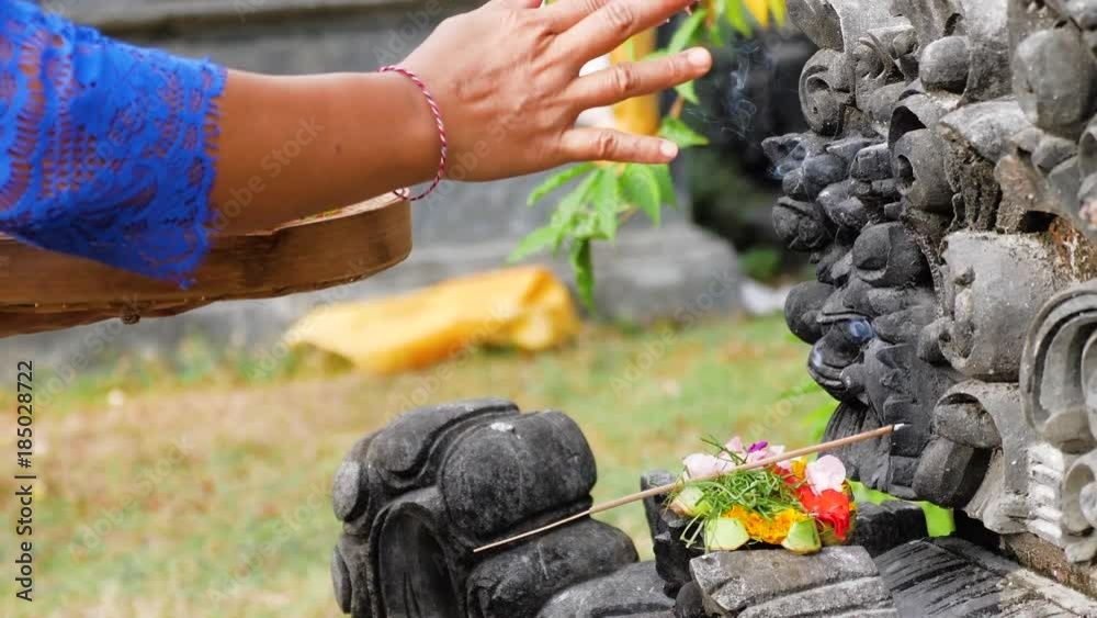 Woman makes prayer movements with her hands in the Hindu temple ...