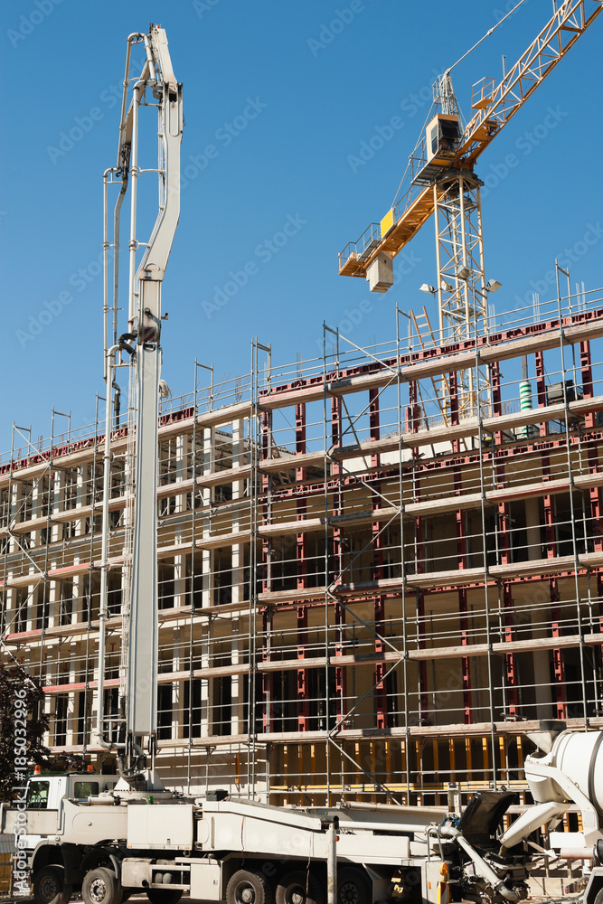 Foto de Ein Kran und eine Betonpumpe arbeiten an einem Neubau unter ...