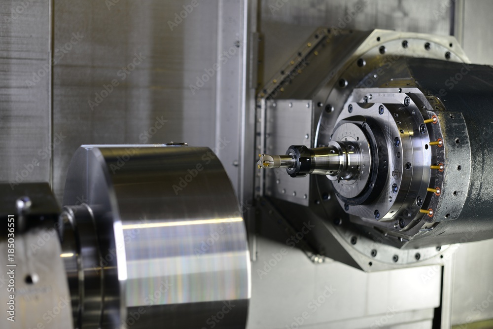 The 5-axis CNC machine while cutting the sample part of turbine.The ...