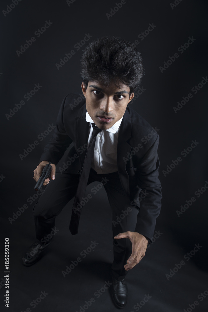 Secret agent posing on black background Stock Photo | Adobe Stock