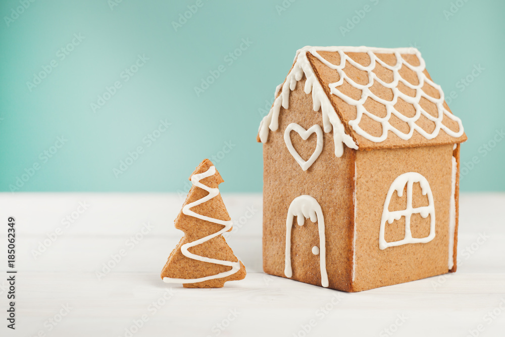 Gingerbread house and gingerbread tree on a light background, copy ...