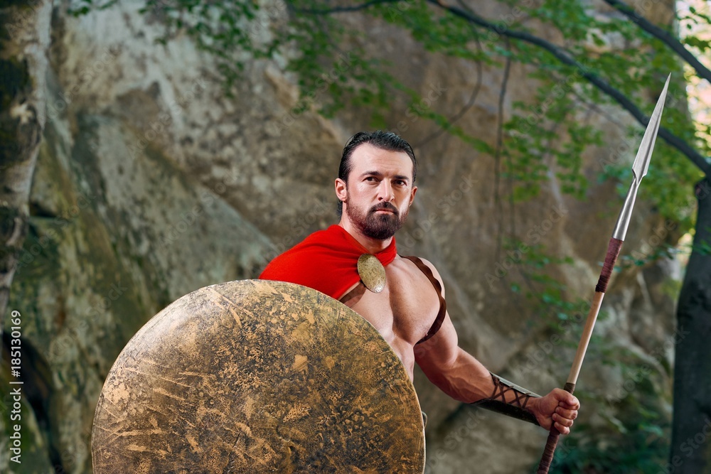 Handsome mature Spartan soldier with a shield and a spear looking to ...