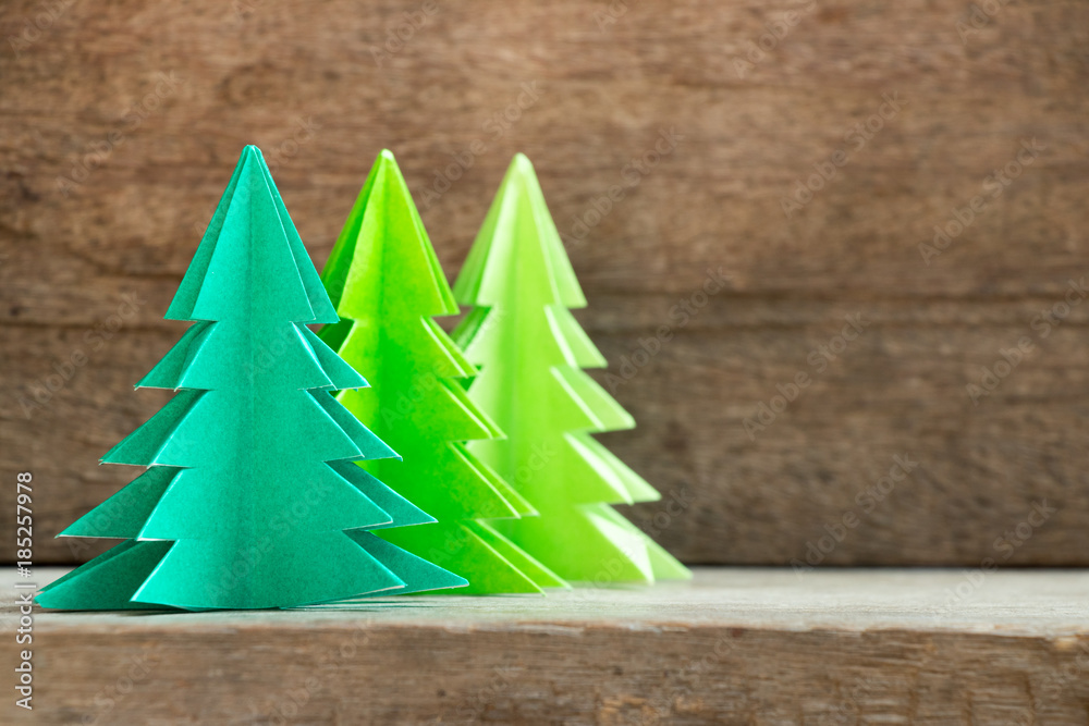 Green paper cut as christmas pine tree on wood background have the copy ...