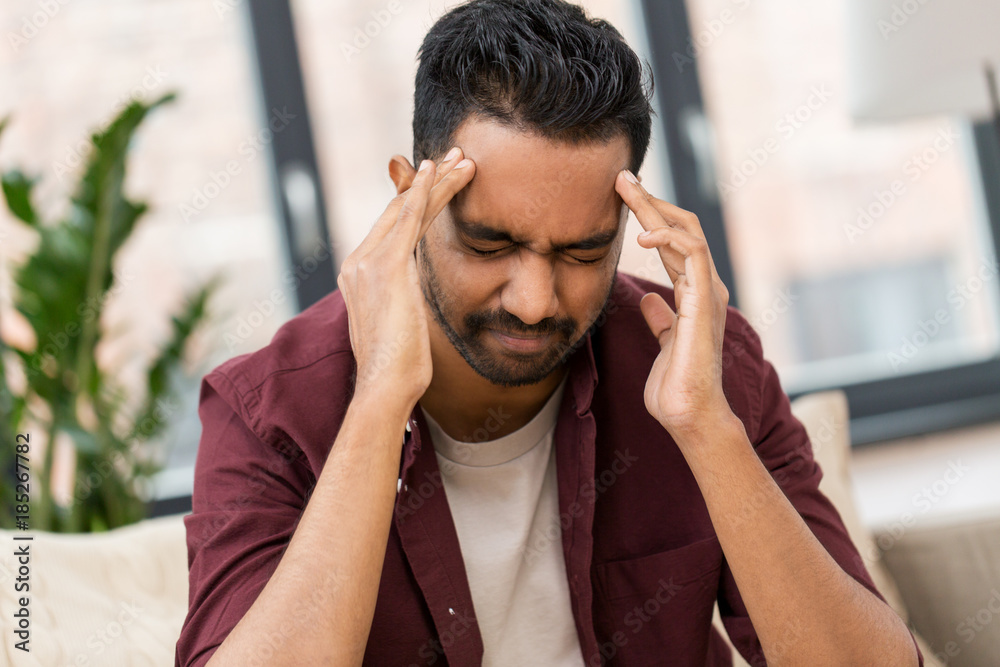 unhappy man suffering from head ache at home Stock Photo | Adobe Stock