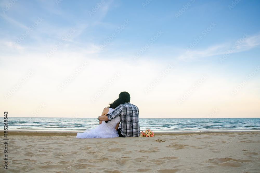 Couple Sitting On Beach Sunset
