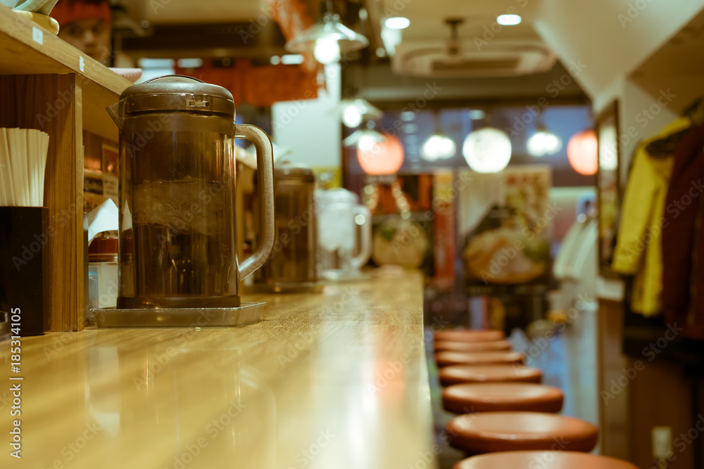 An empty bar with jugs of water inside a popular ramen shop in Shinjuku ...
