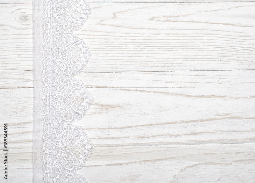 White lace on a worn white wooden background with copy space on the ...