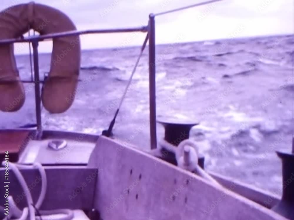 View from cockpit of sailboat looking aft over windy ocean waters off ...
