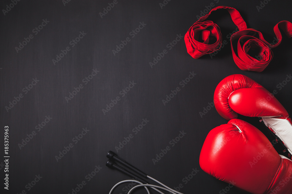 Professional red boxing gloves, wraps, and skipping rope on black ...