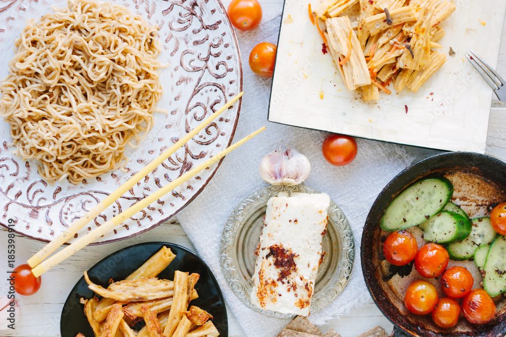 Top view of asian table with chinese noodles, roasted paneer or tofu ...