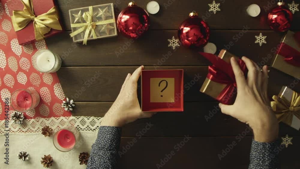 Man opens Christmas gift box with stick note with question mark on it ...