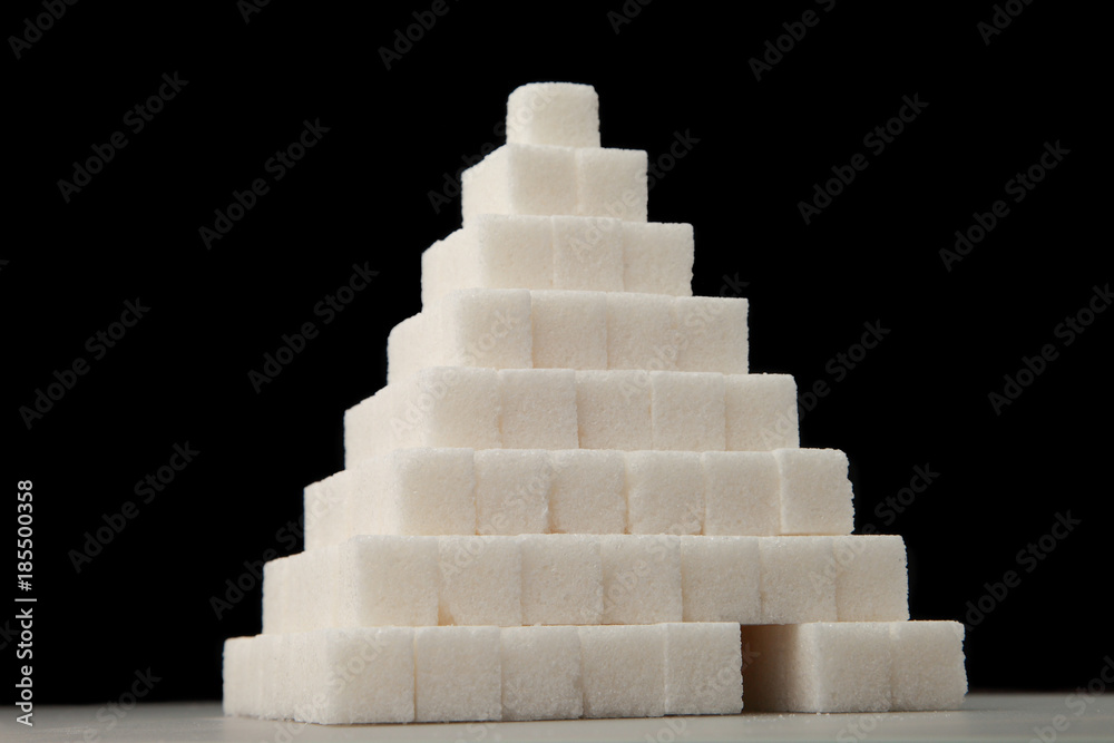 Pyramid of sugar cubes/ Pyramid of sugar cubes, isolated on a black ...