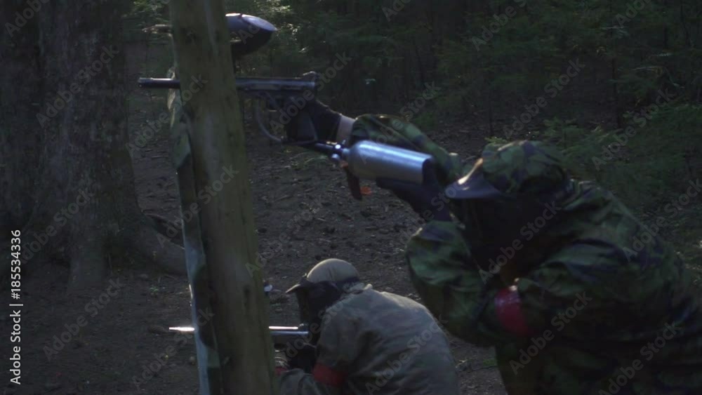 Vidéo Stock Paintball player shooting from gun with color splash on ...