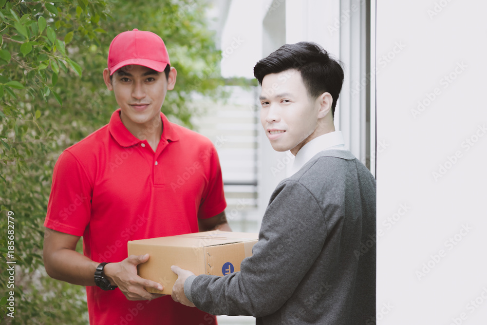 Young logistic career concept. Happy delivery man giving his package to ...