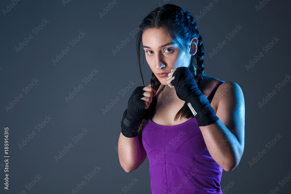 Female boxer makes a fight with a shadow, dark background with space ...