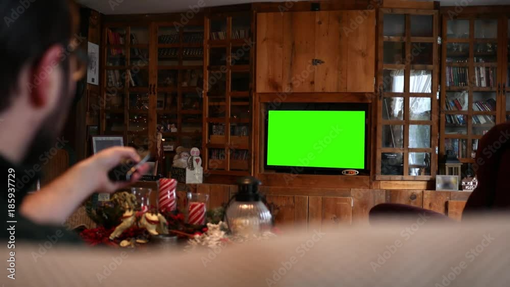 Vidéo Stock Millennial Male using remote to change channels on Green ...