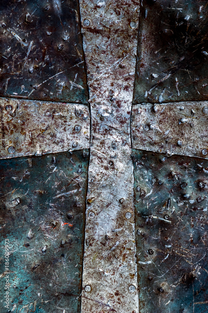Detailed close-up photo of a christian cross symbol on a rusty battered ...