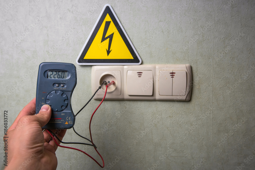 Electrician makes electrical measurements; jumps tension, electrical ...