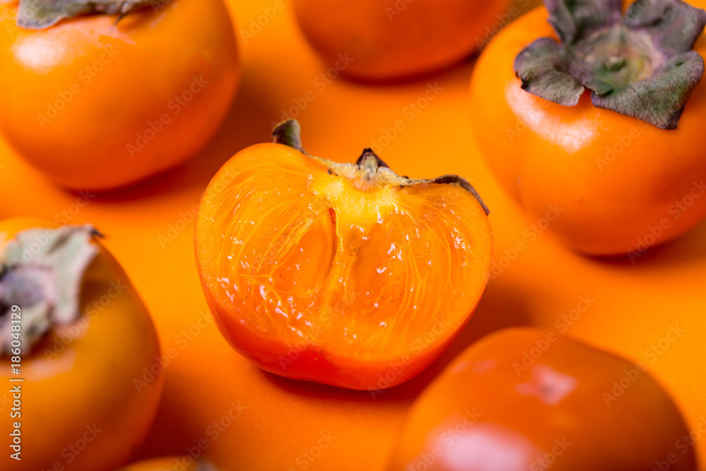persimon at orange background Stock Photo | Adobe Stock