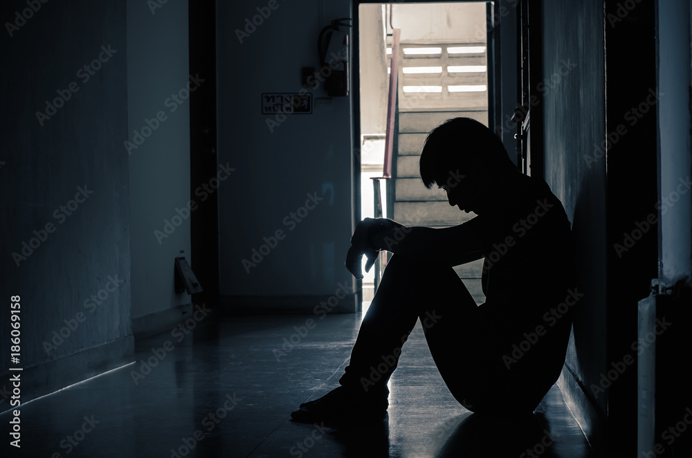 Silhouette of man sitting alone,Sad and Serious Man sitting hug his ...