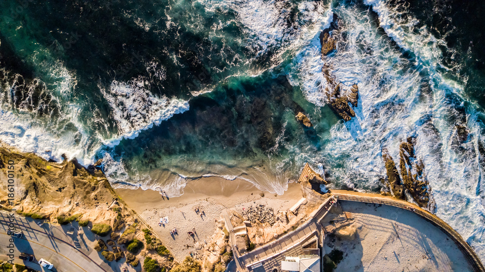 Foto de Drone view of waves hitting the rocks and the beach at seashore ...