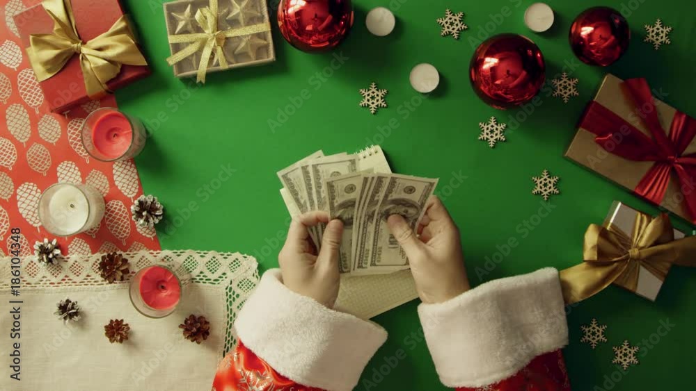 Santa Claus counting his money over notebook with expenses writings by ...