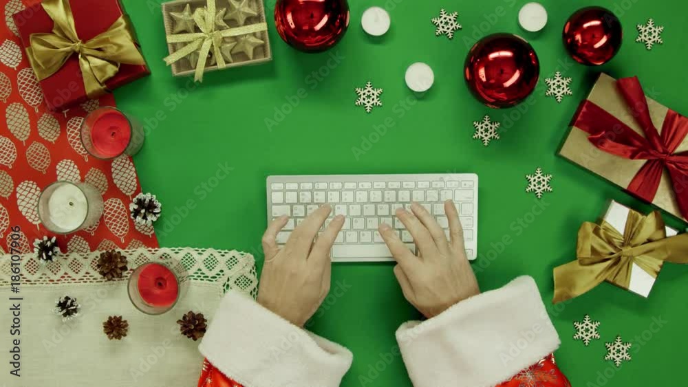 Santa Claus typing on wireless keyboard by Xmas table with chroma key ...