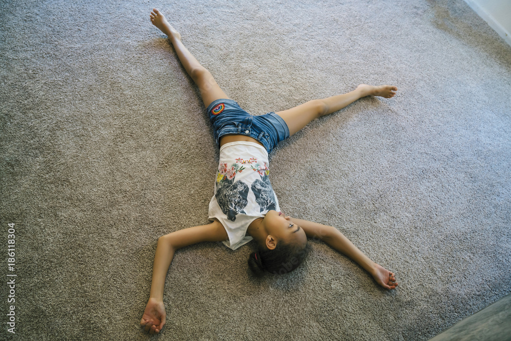 Bored girl laying on the living room floor Stock Photo | Adobe Stock