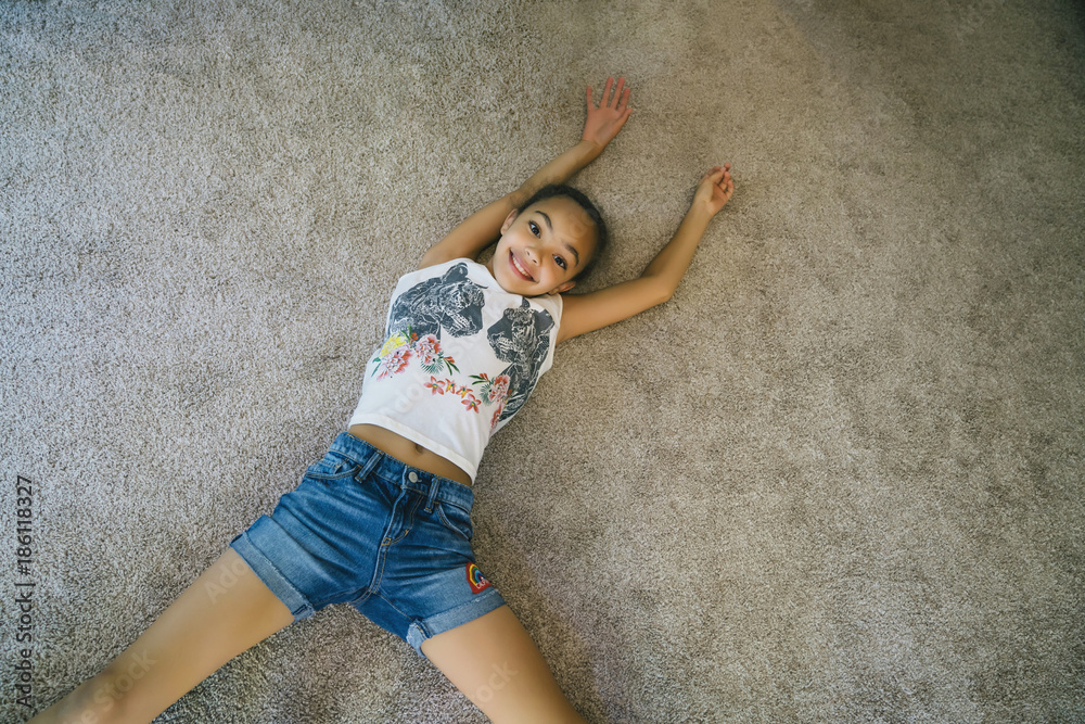 Happy girl laying on the living room floor Stock Photo | Adobe Stock