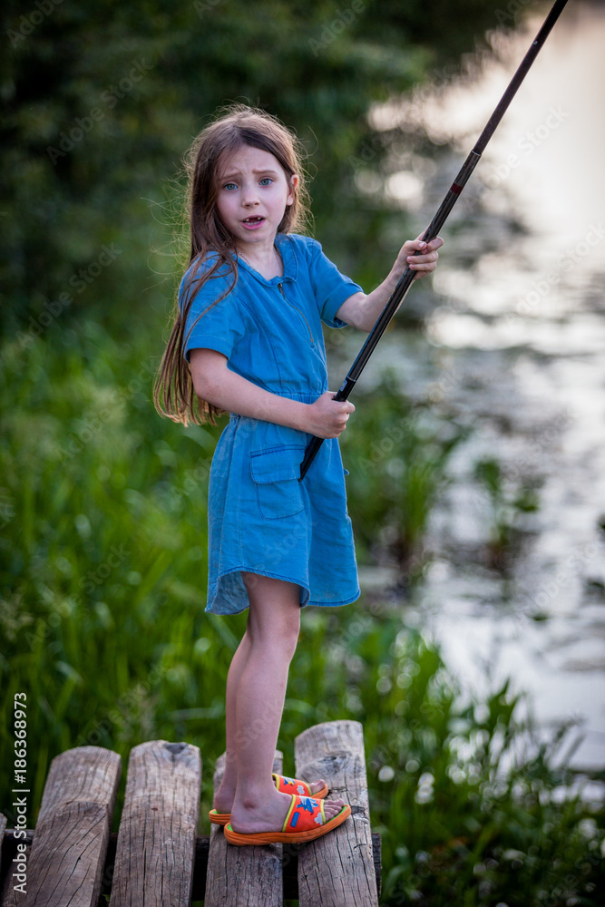 Cute child girl fishing from the shore Stock Photo | Adobe Stock