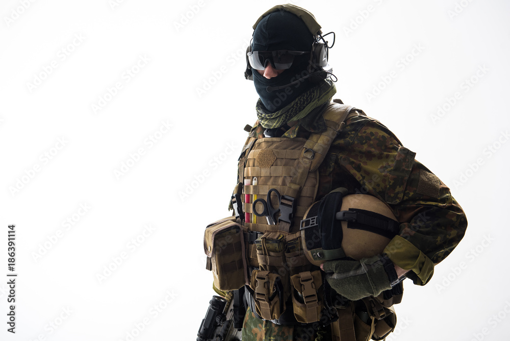 Portrait of serious soldier speaking by digital device while holding ...