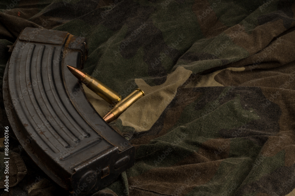 Rusty AK-47 magazine and bullets on camouflage textile background Stock ...
