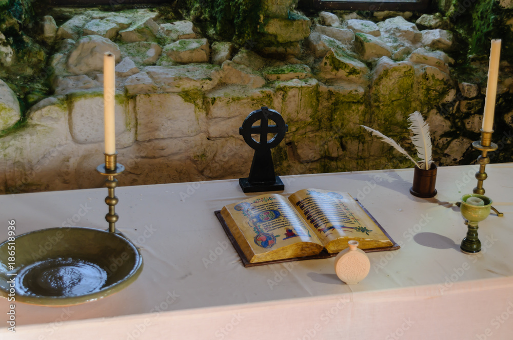 Medieval church altar with quills, cross, candles and a Bible Stock ...