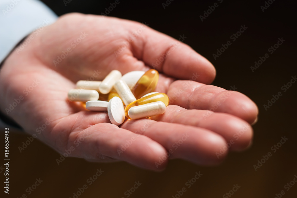Woman take in the hand variety medication pills, yellow capsules of ...