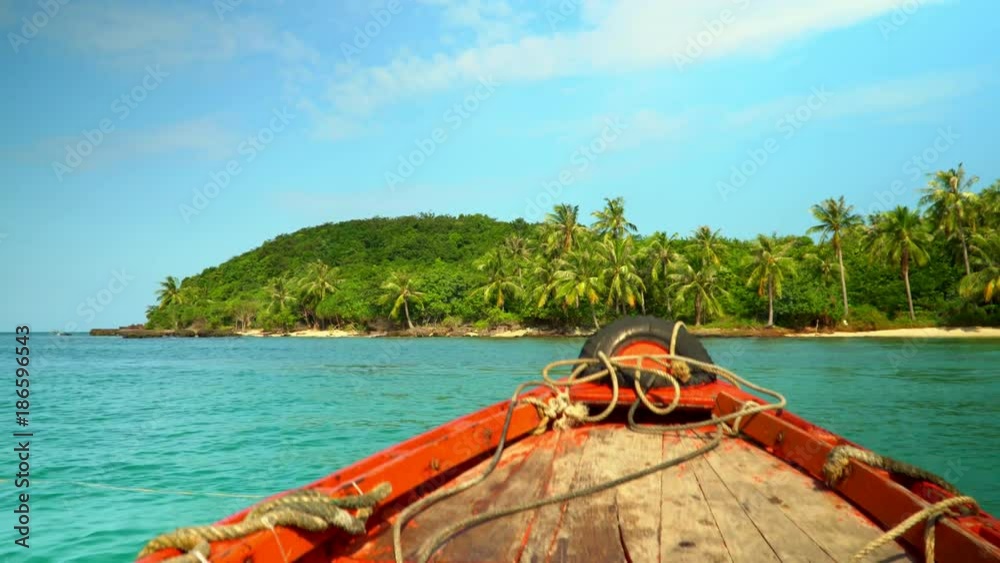 The small fishing boat floats to the tropical island. The beautiful ...
