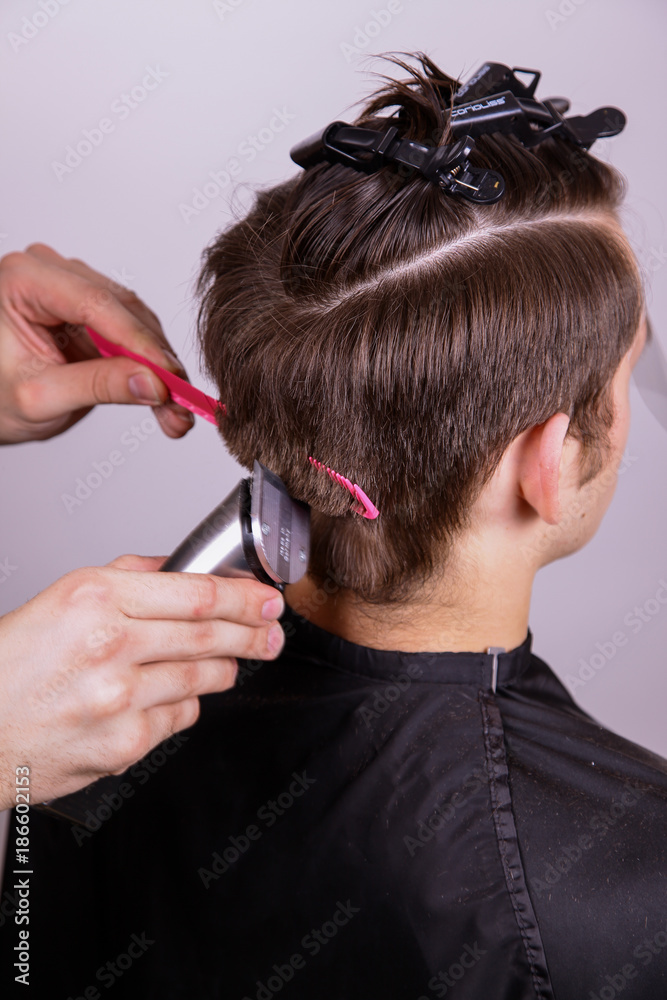 The process of male haircuts. A hairdresser is cutting a guy. Barber ...