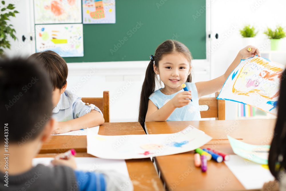 happy little girl drawing in the classroom Stock Photo | Adobe Stock