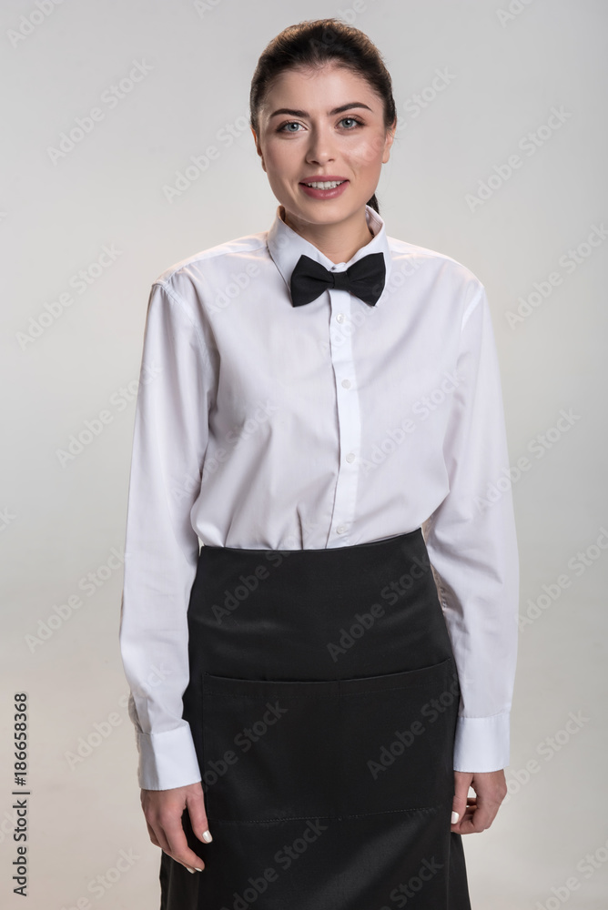 Waitress uniform. Cheerful charming professional waitress smiling while ...